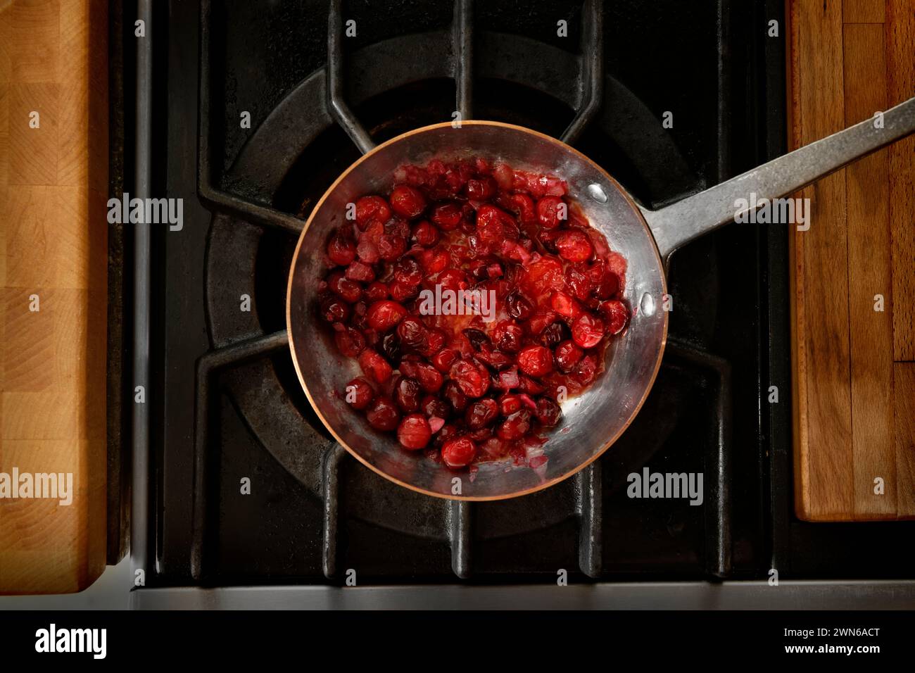 A top view of cranberries simmering on the stove for homemade cranberry ...