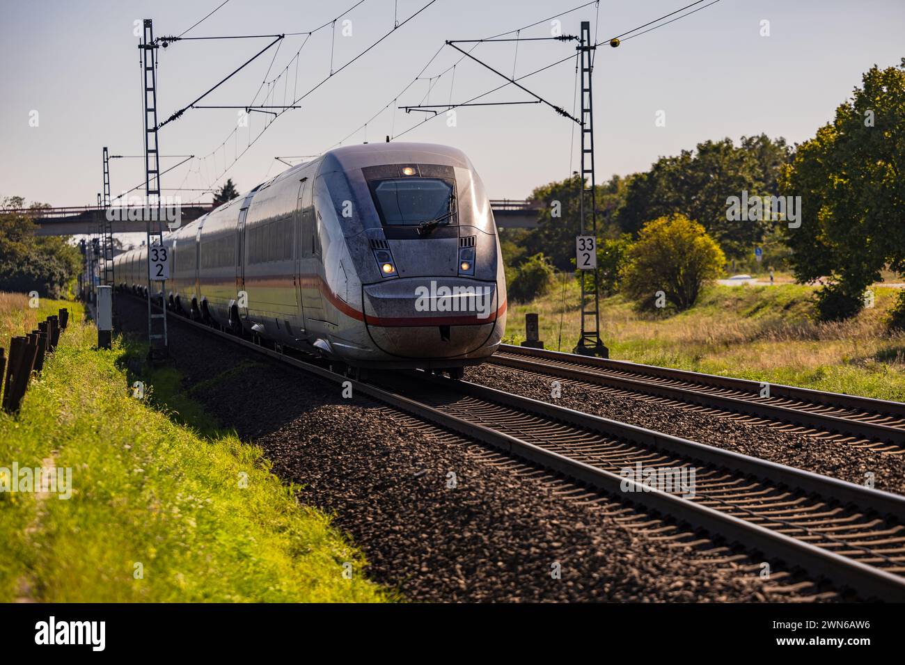 An ICE Express train on a track of a railroad line with fields and ...