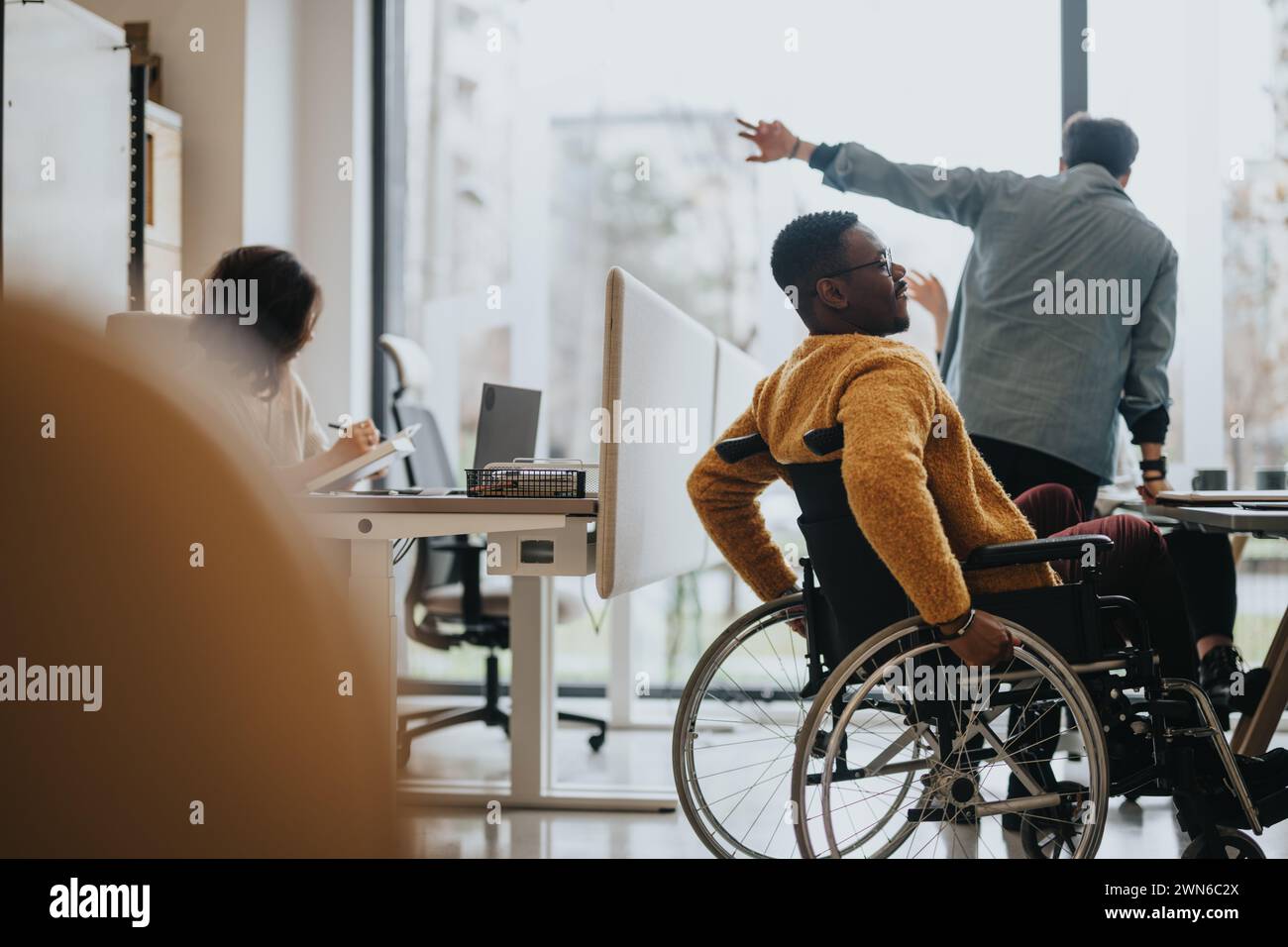 Inclusive modern office environment with a wheelchair-using employee ...