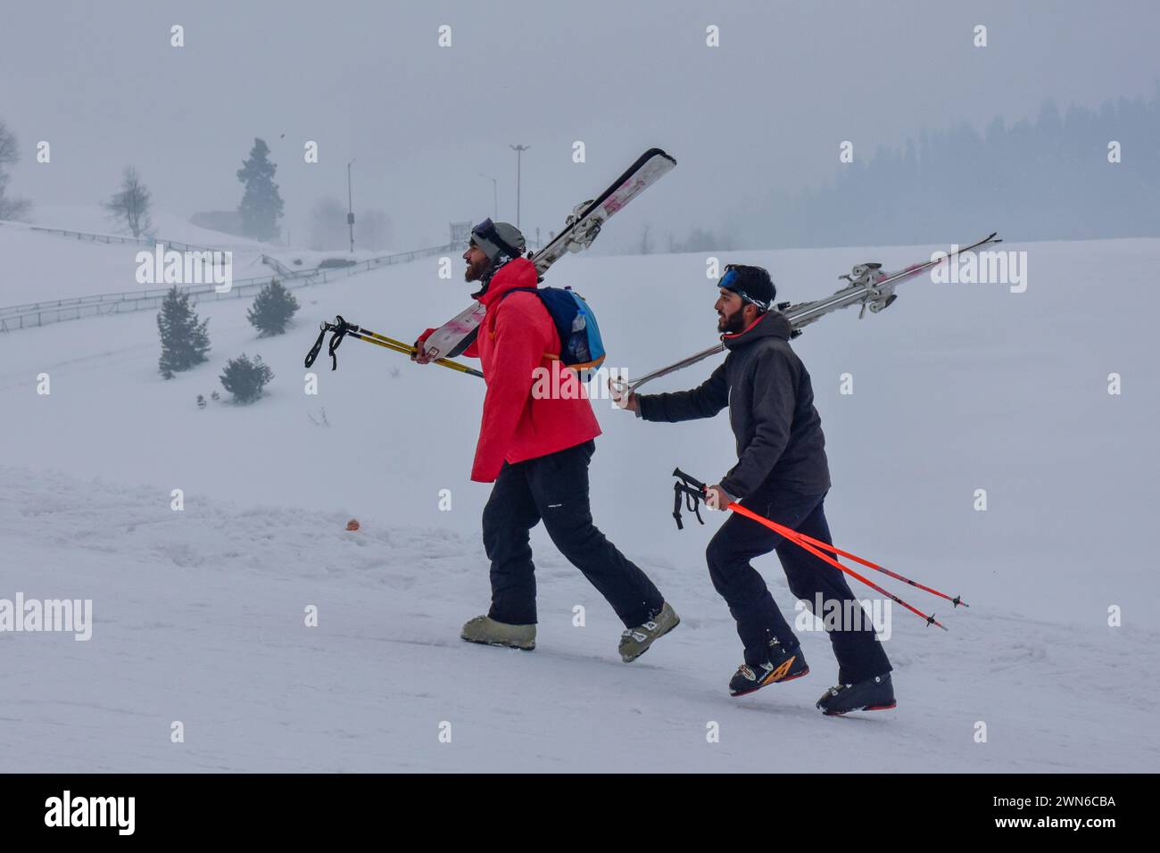 Kashmiri skiers walk up the slope at the Gulmarg ski-resort, about ...