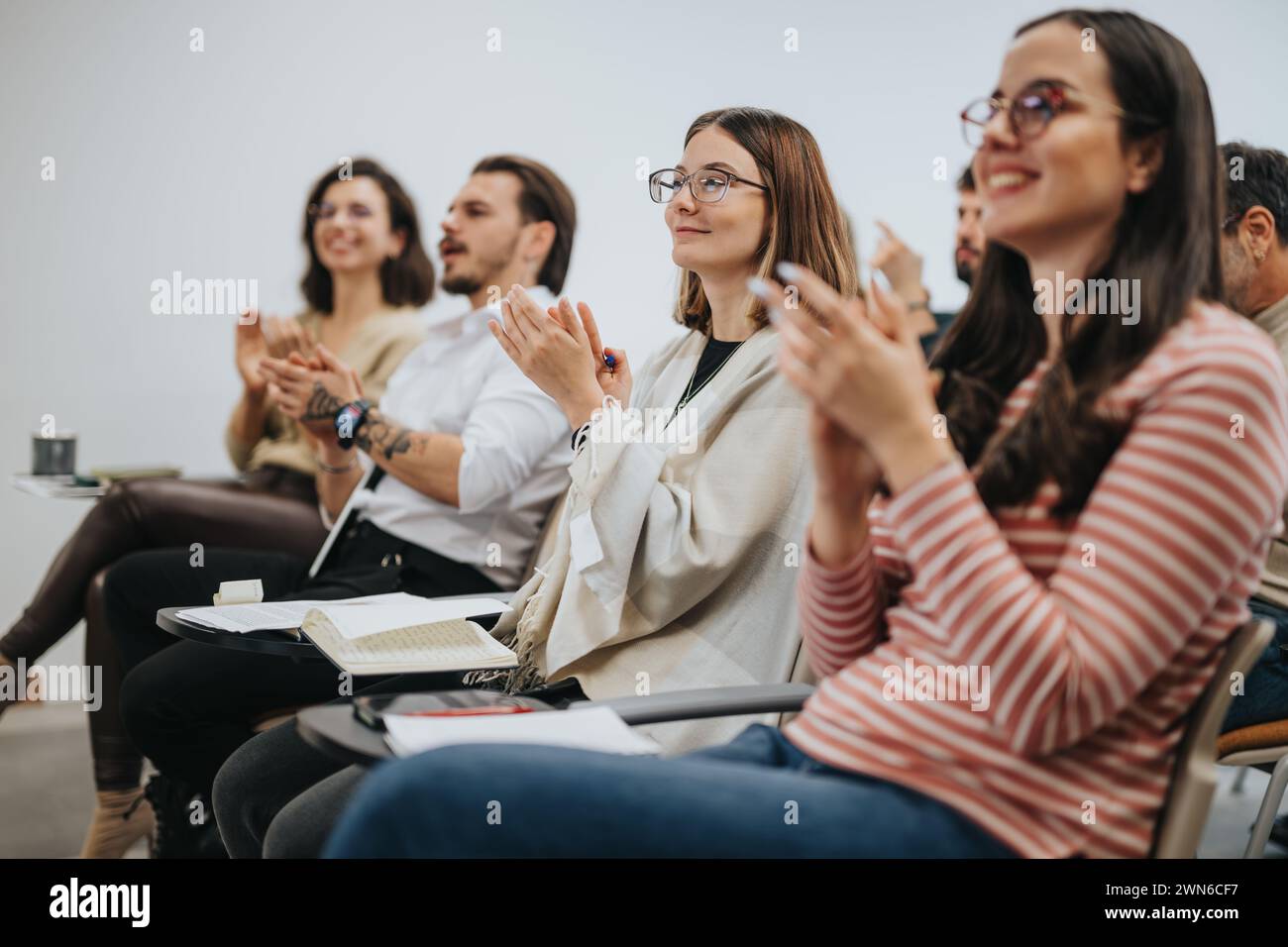 Engaged audience clapping during a conference presentation in modern ...