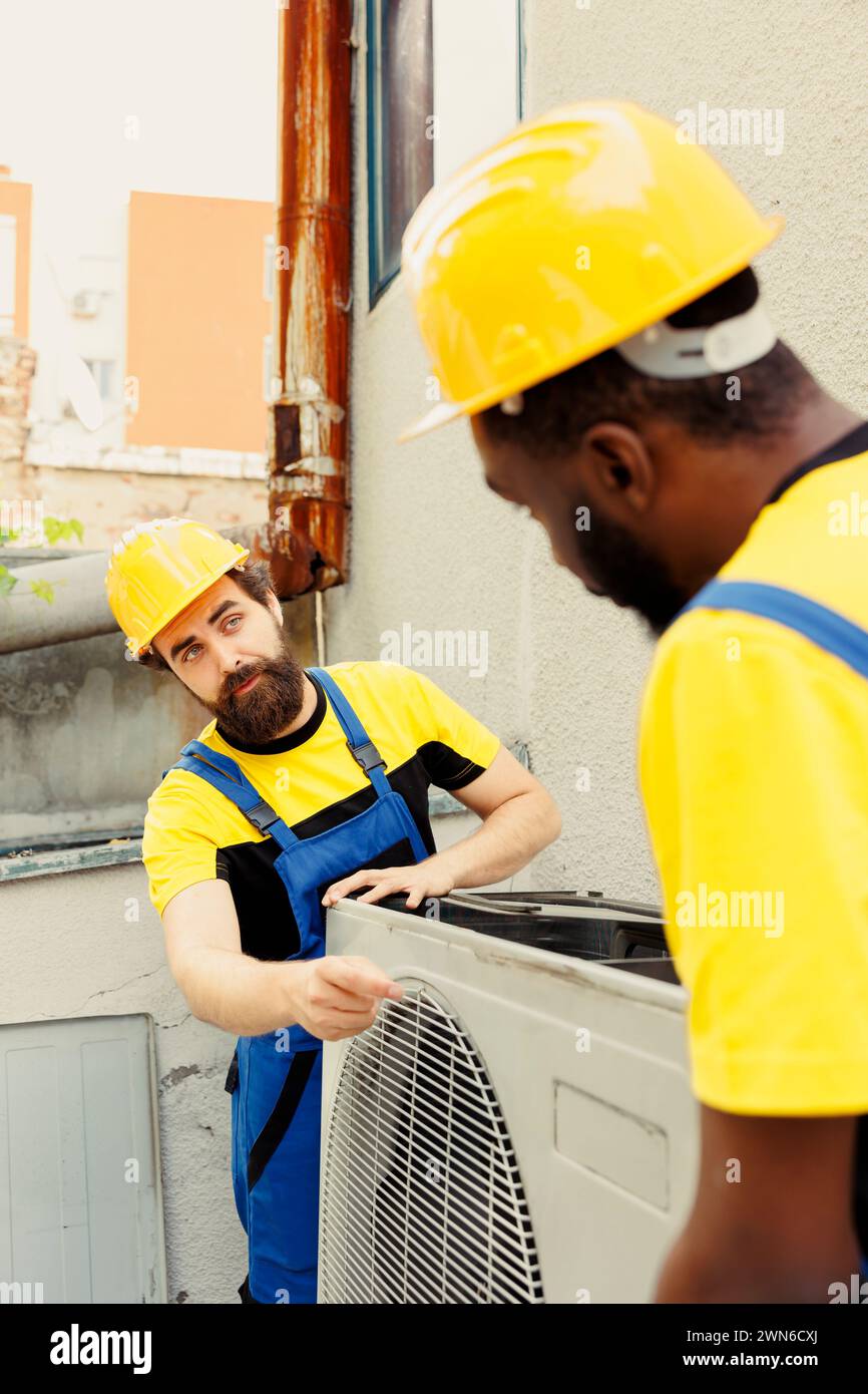 Skilled experts installing new condenser for comissioning customer ...