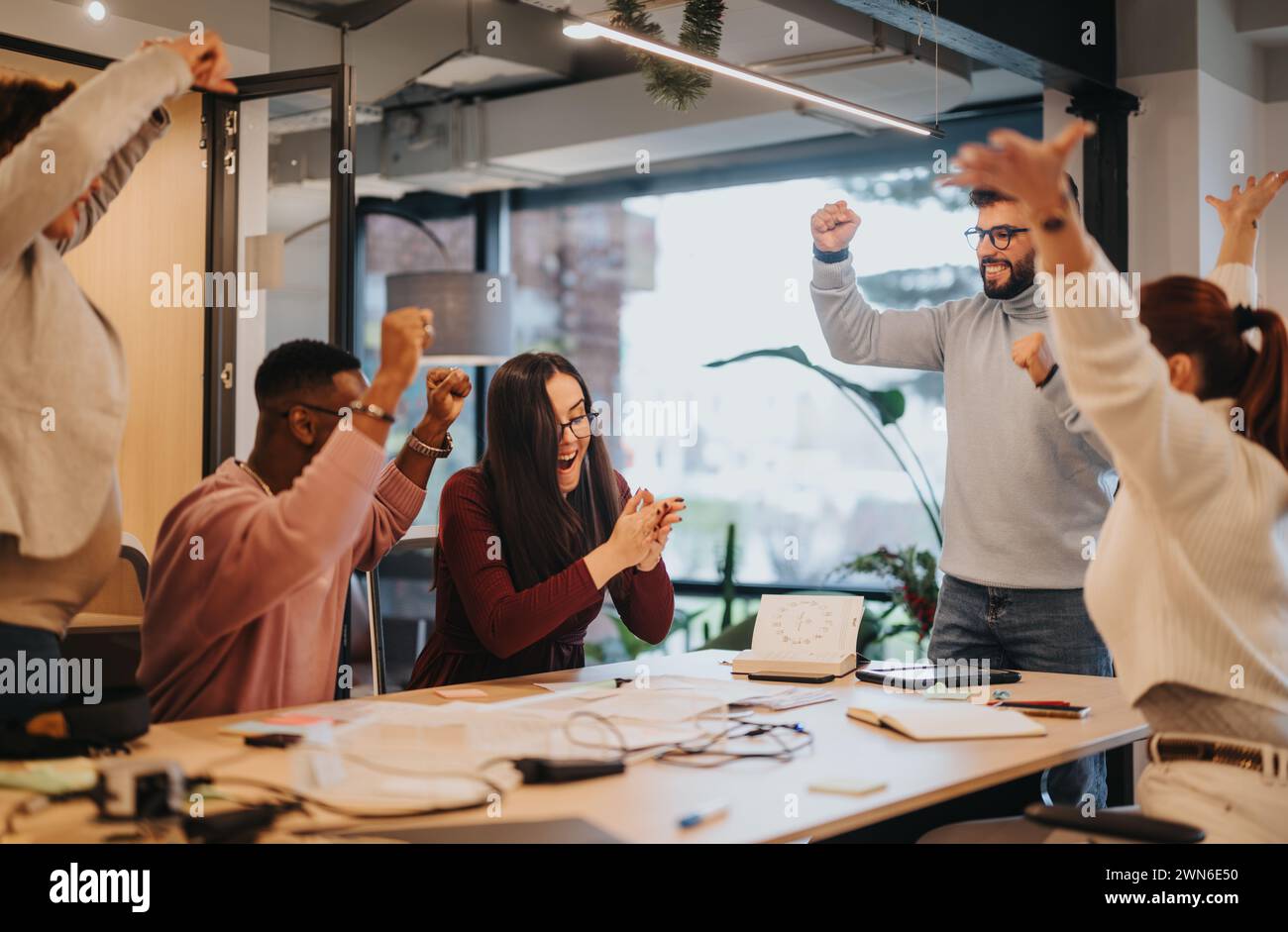 Business colleagues sitting in office, celebrating a successful project ...