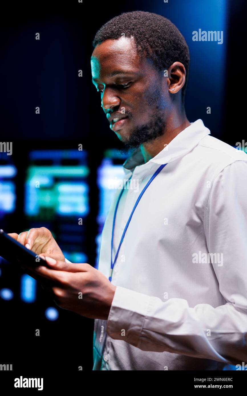 African american admin using laptop to review energy consumption across ...