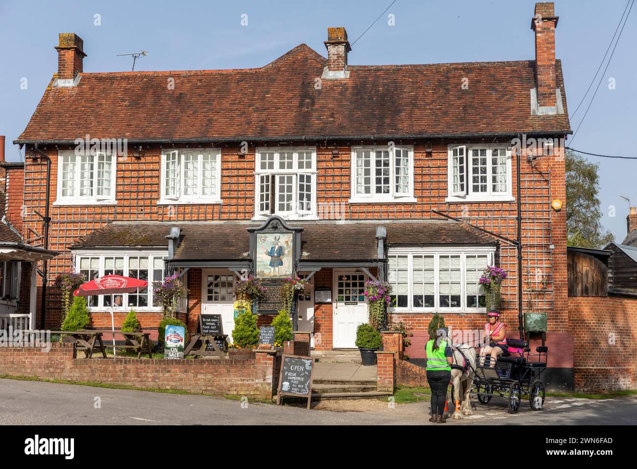 Minstead village near Lyndhurst, two ladies with horse drawn cart ...