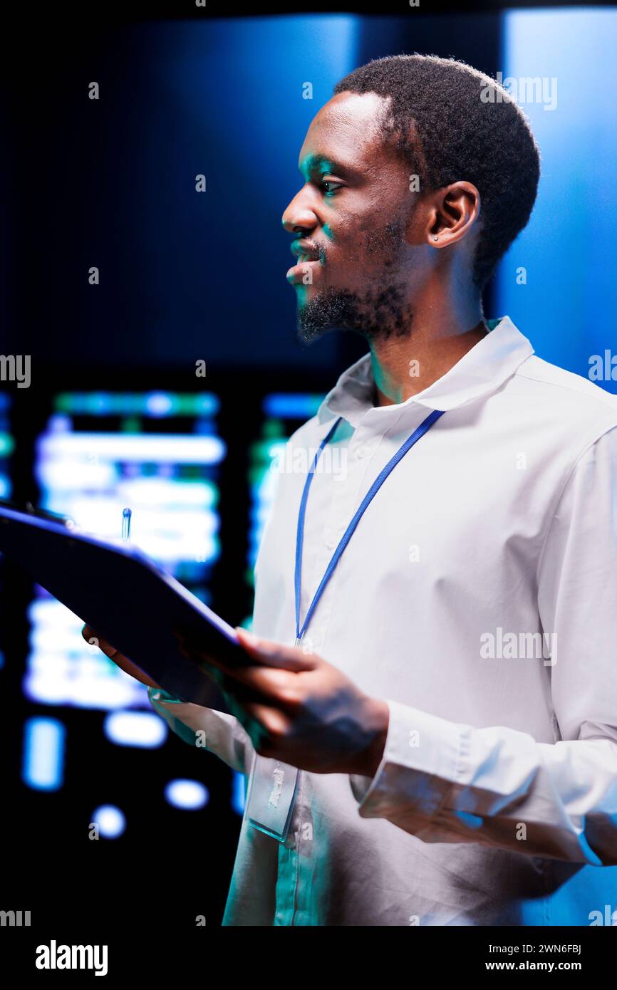 Engineer using clipboard to write down findings after monitoring energy ...