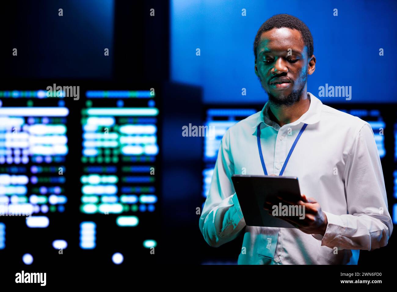 Focused admin using tablet to assess energy consumption across server ...