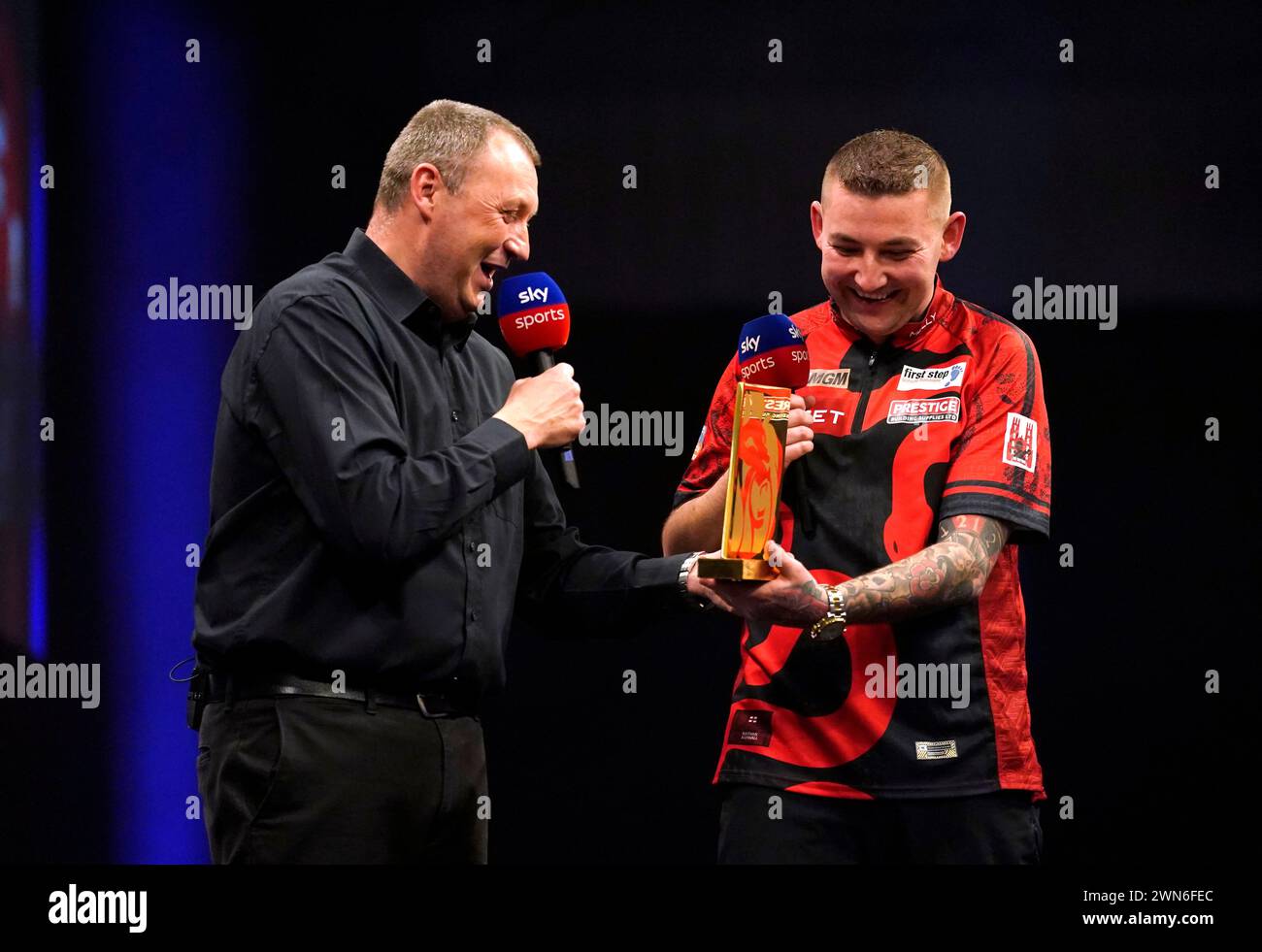 Nathan Aspinall is presented with the trophy after winning the final against Rob Cross (not ...