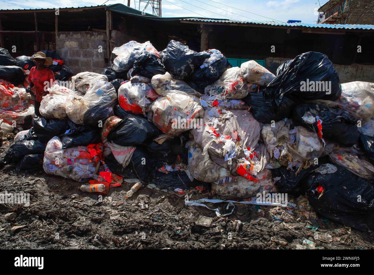 Nairobi, KENYA. 28th Feb, 2024. A waste collector walks past waste bags ...