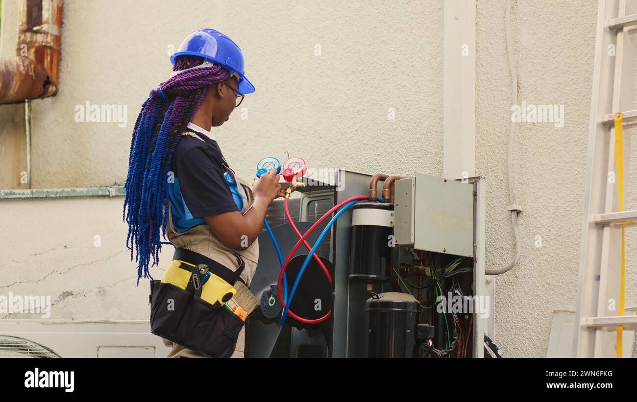 Trained engineer calibrating manifold gauges during comissioned outside ...