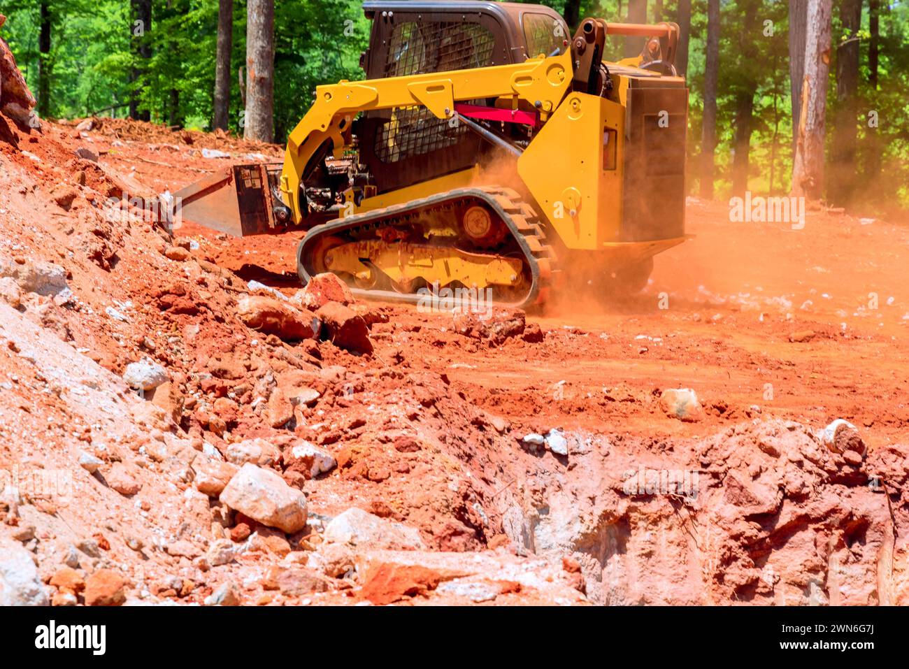 Excavator bucket skid steer loader unloading gravel at construction ...