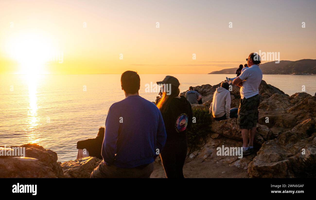 People watching the sunset over the Pacific Ocean in Malibu, California ...