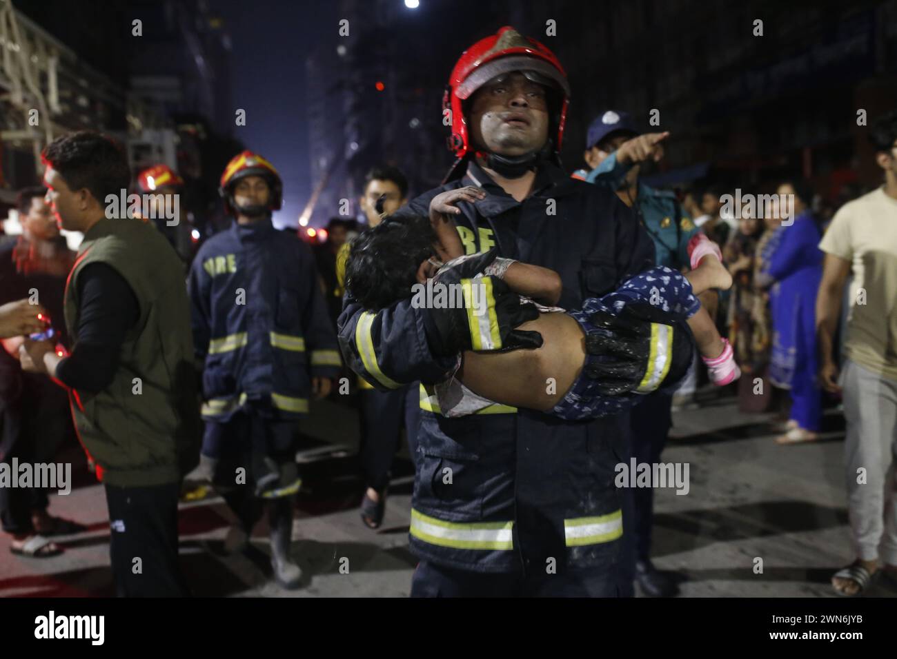 A firefighter is carrying an injured person during rescue operations ...
