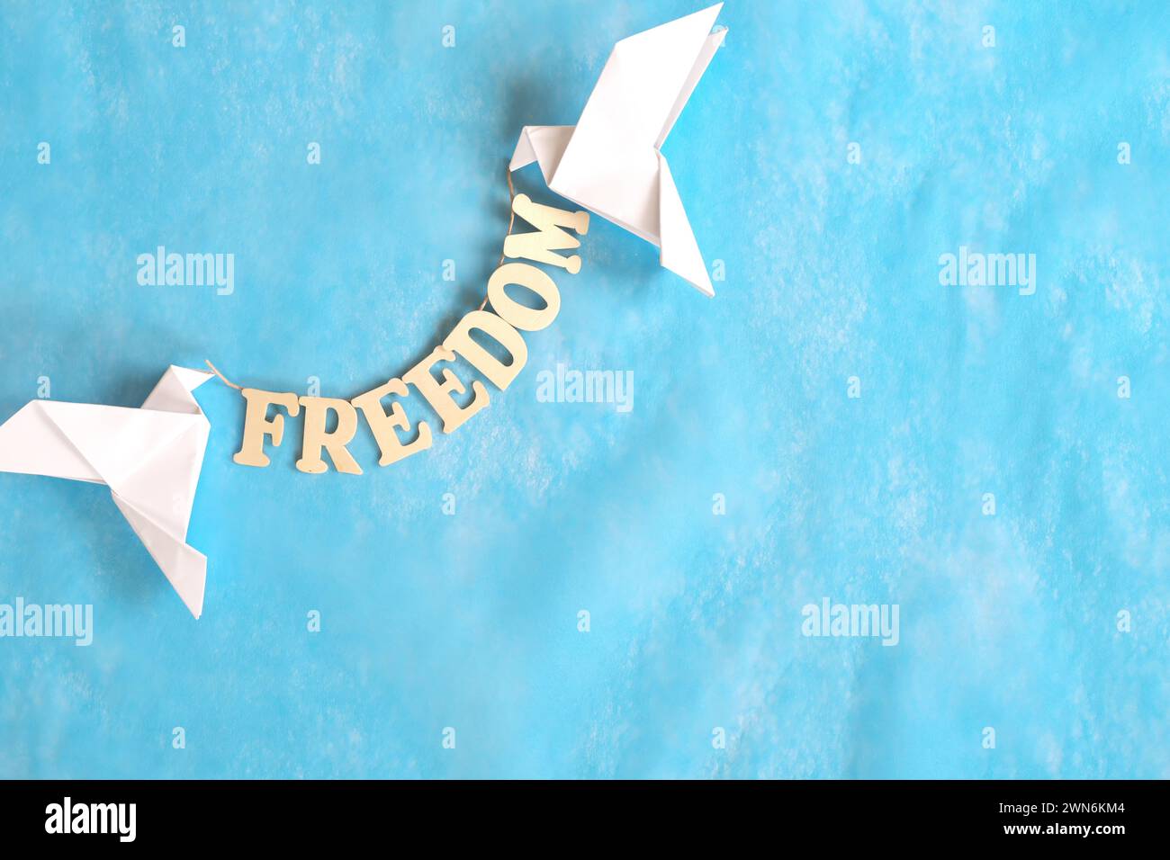 Concept of freedom. White dove origami carrying word heaven in sky blue ...