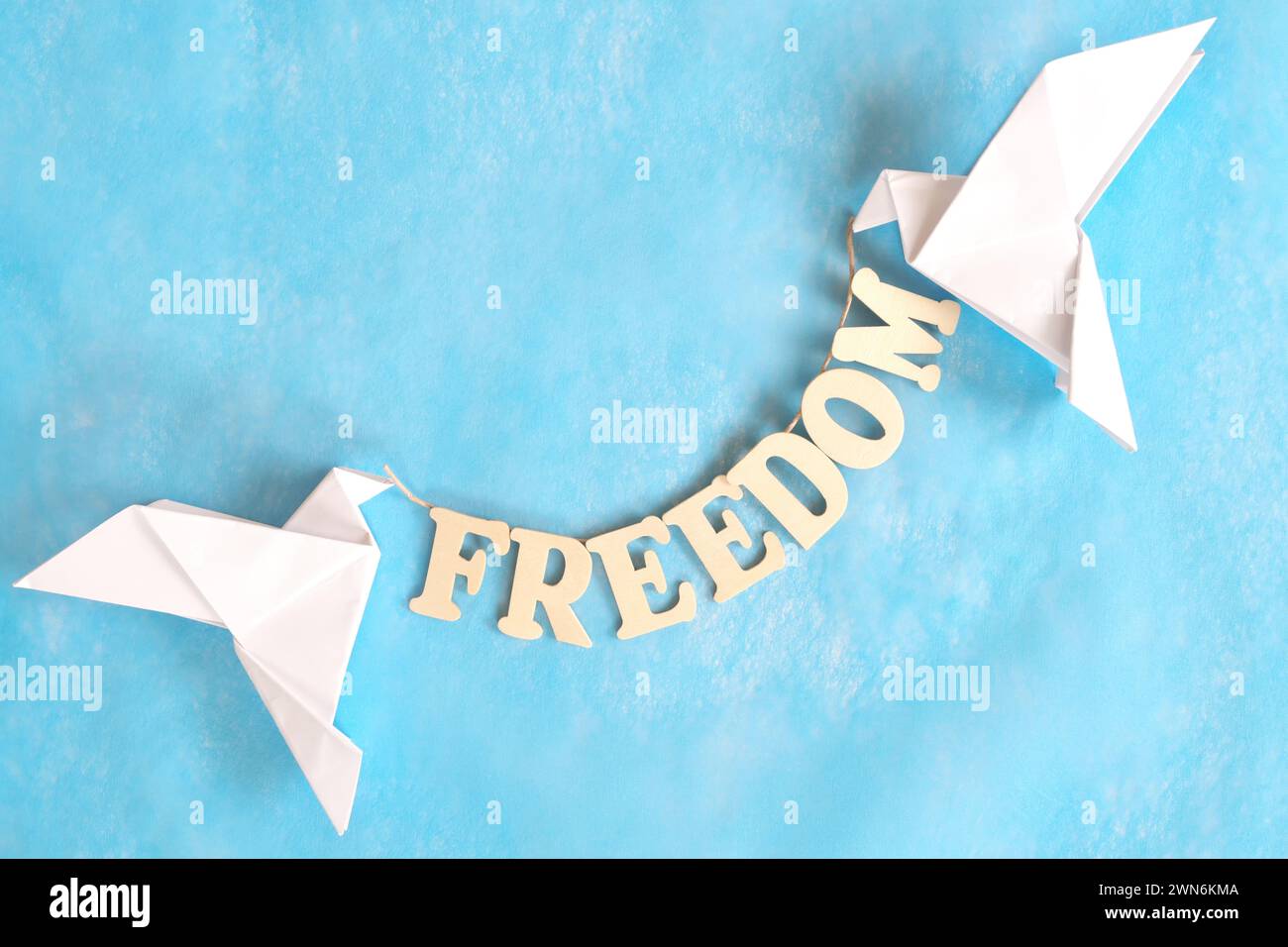 Concept of freedom. White dove origami carrying word heaven in sky blue ...