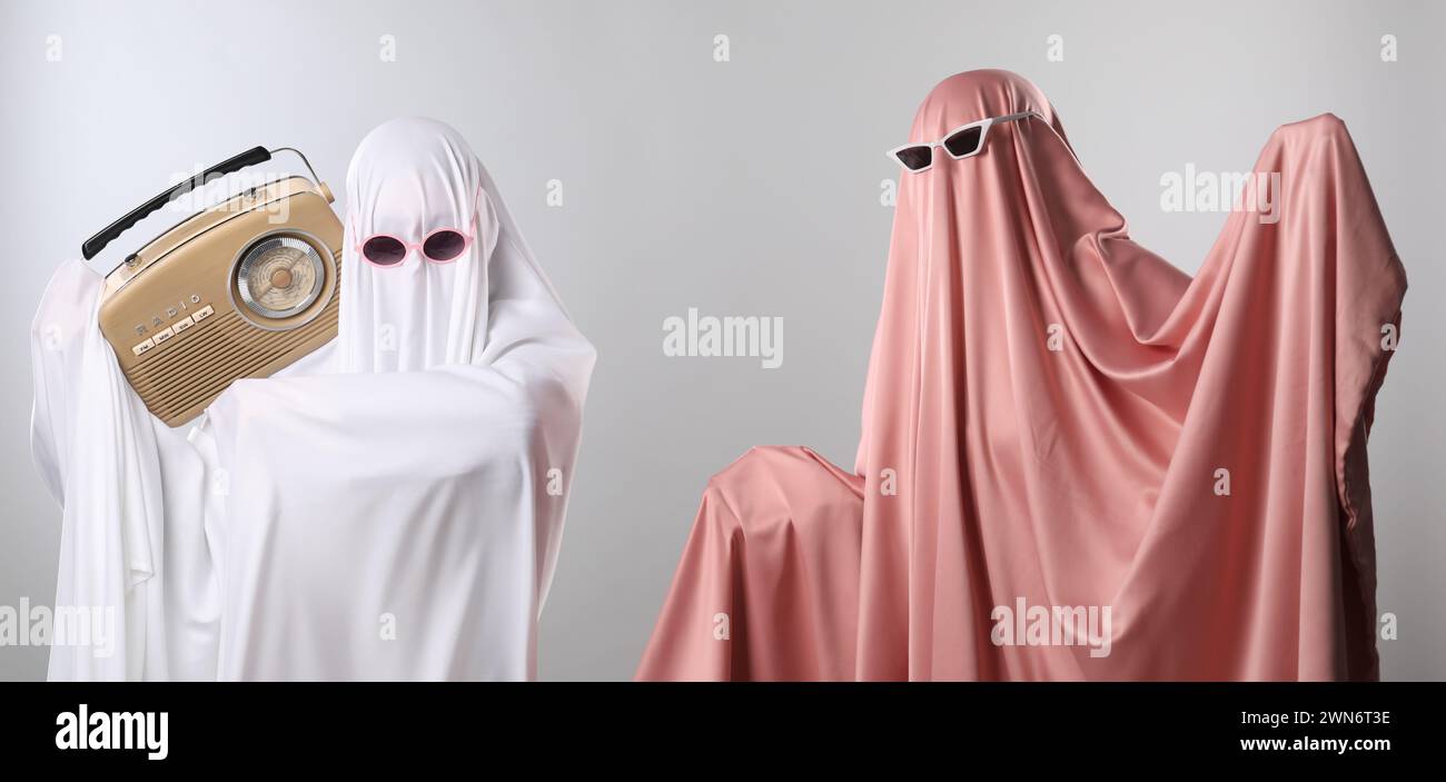 Glamorous ghosts. Women in color sheets and sunglasses with retro radio ...