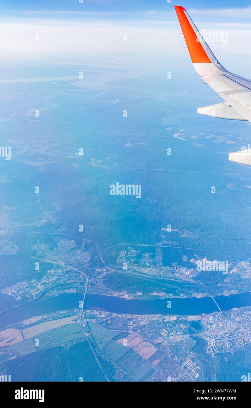 Aerial view from airplane window above green ground. View from the ...