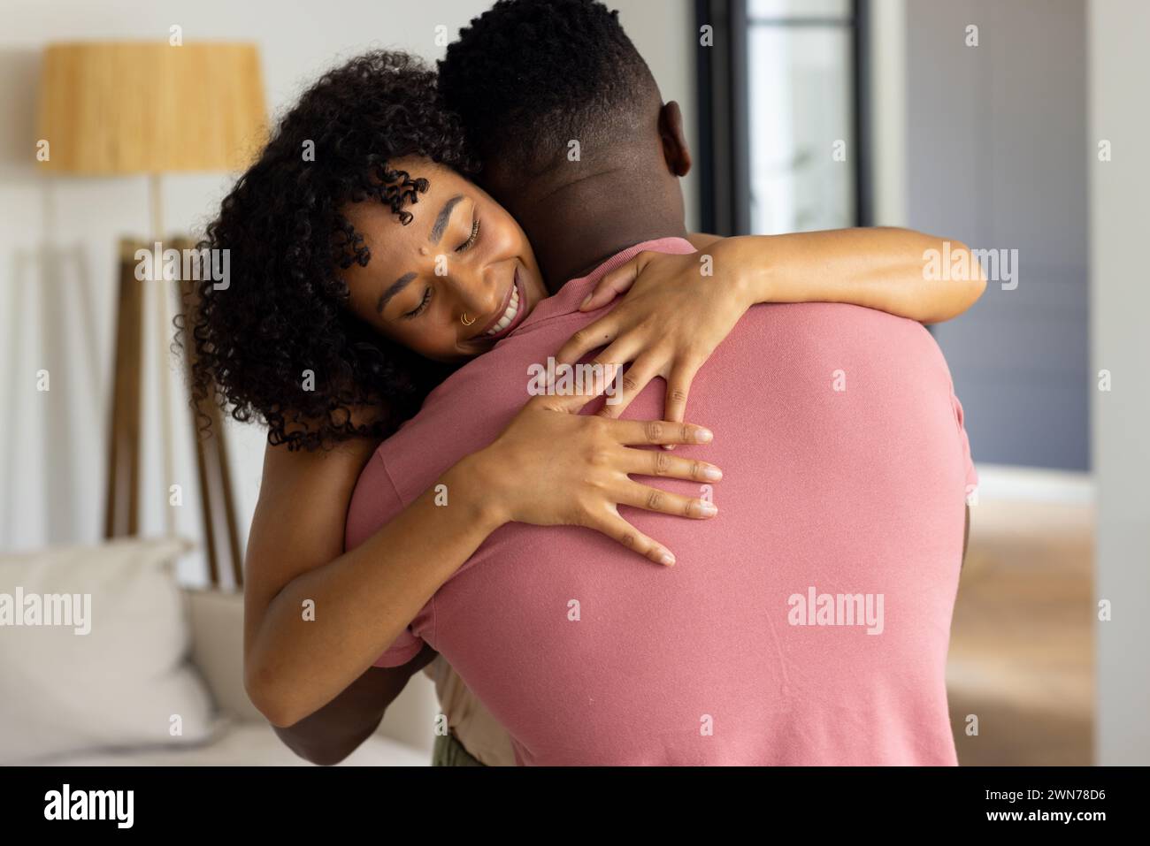African American man receives a warm embrace from a young biracial woman at home Stock Photo - Alamy