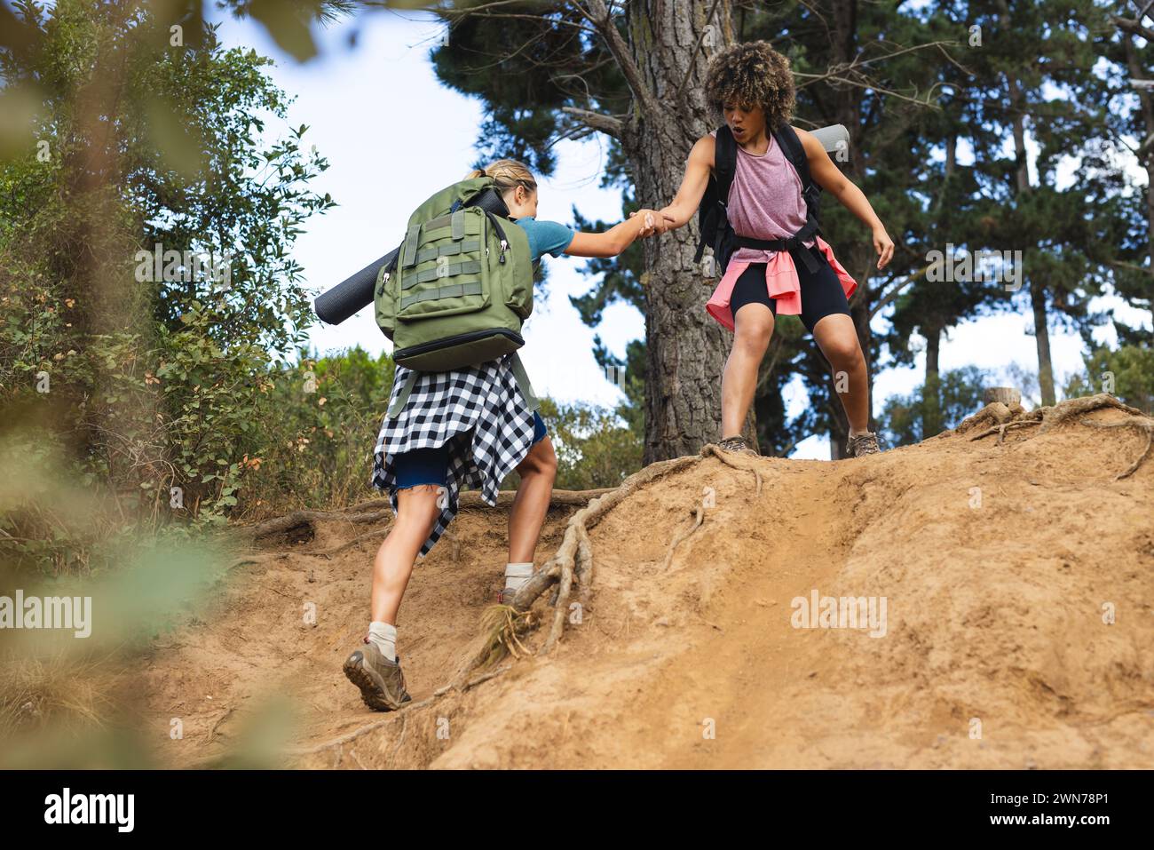 Two women team up for an adventurous hike, showcasing unity Stock Photo ...