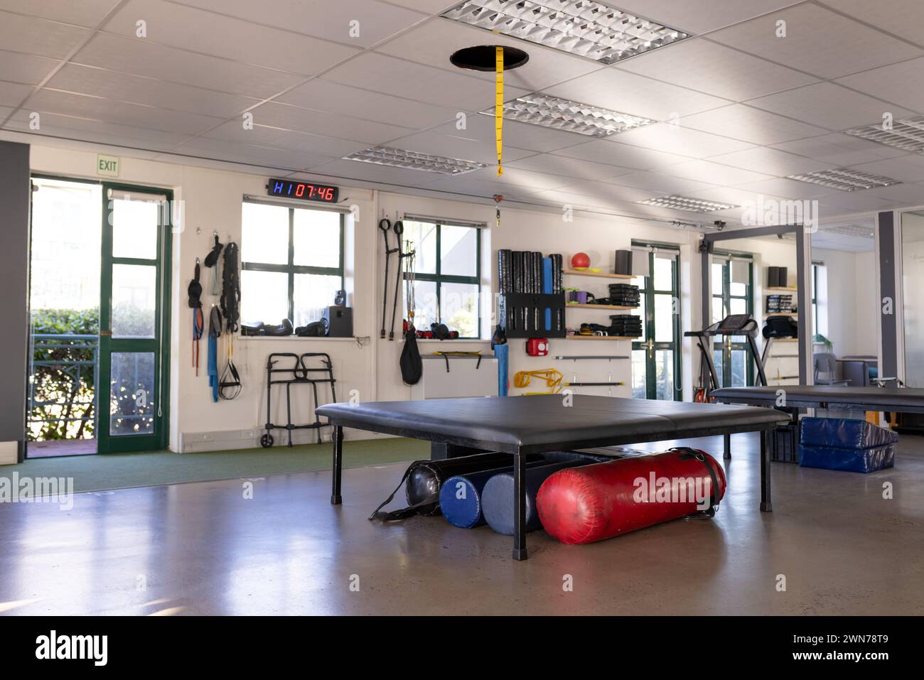 A spacious room features gym equipment like mats and weights, with a ...