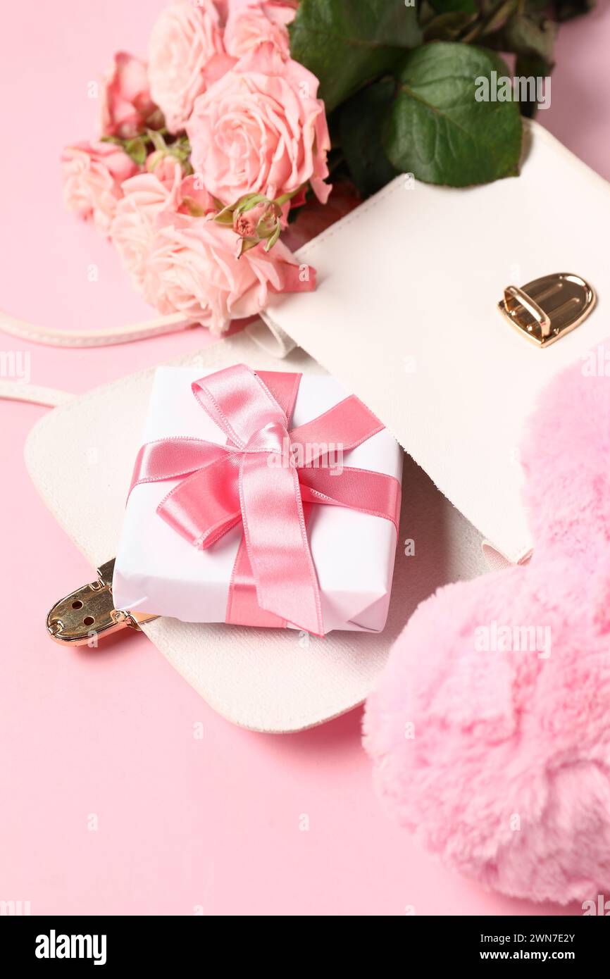 Purse with fit box, heart and bouquet of roses on pink background ...