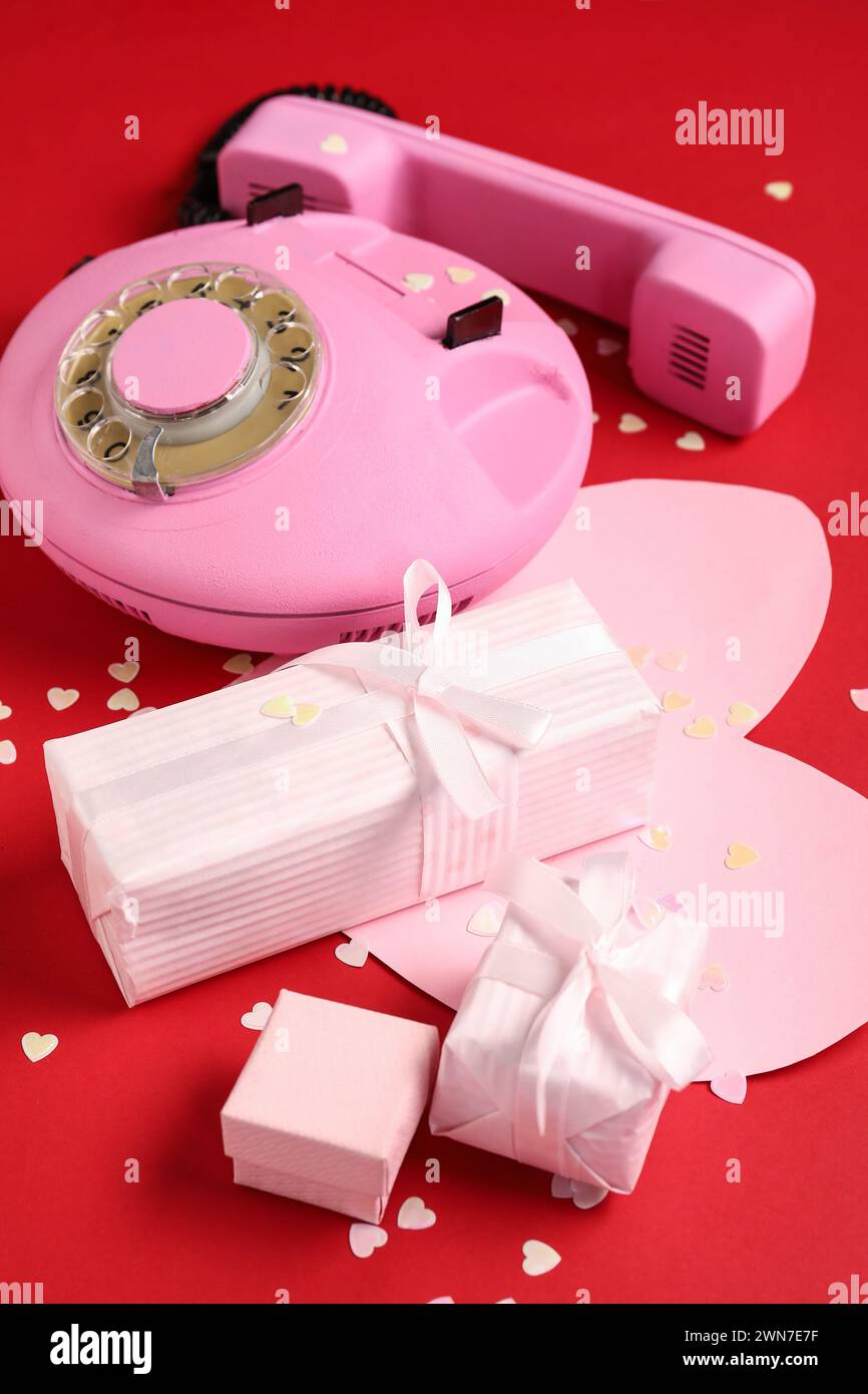 Beautiful gift boxes with paper heart and retro telephone on red ...