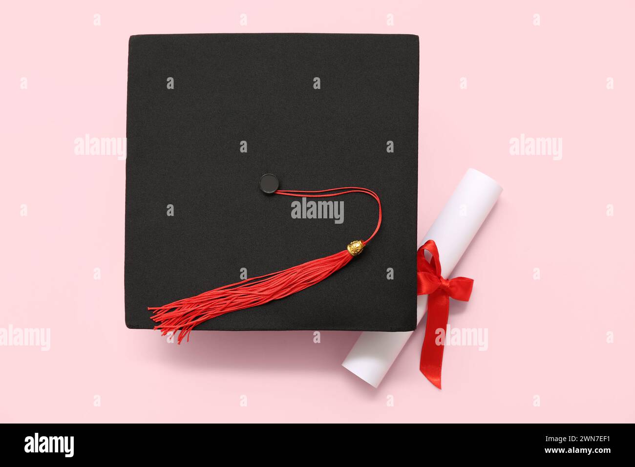 Graduation hat and diploma on pink background Stock Photo - Alamy