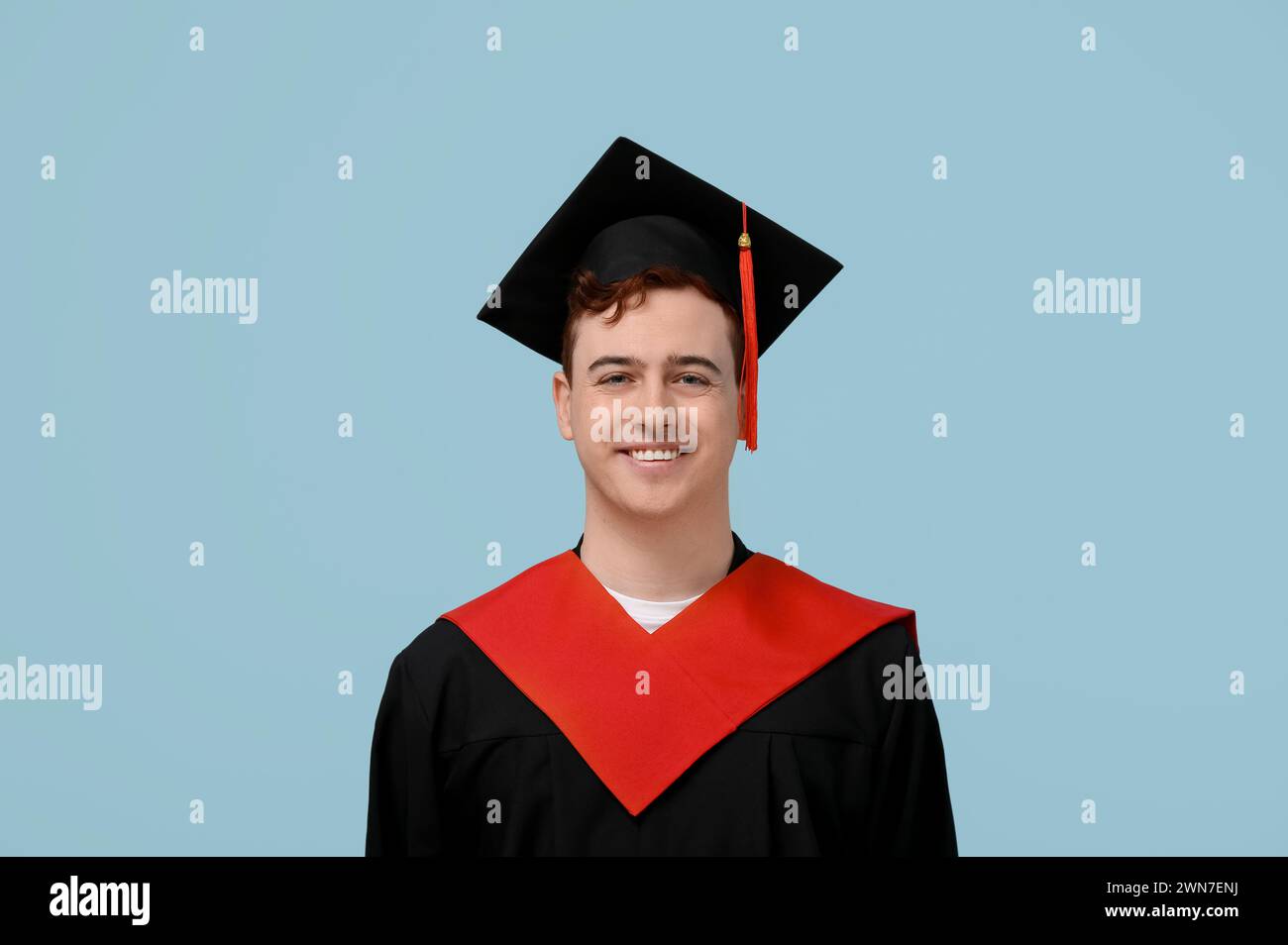 Happy male graduating student on blue background Stock Photo - Alamy