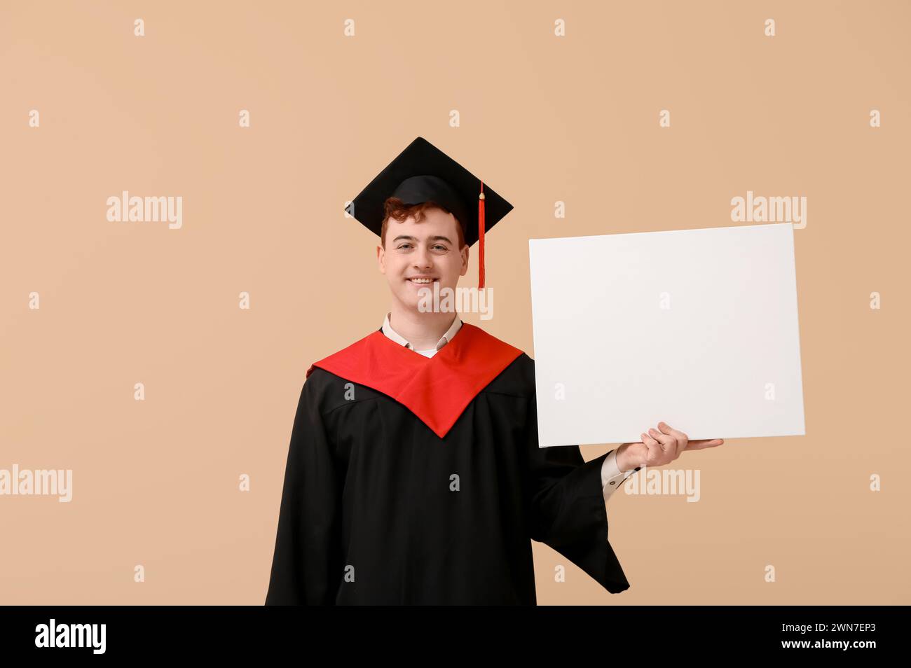 Male graduating student with blank poster on beige background Stock ...