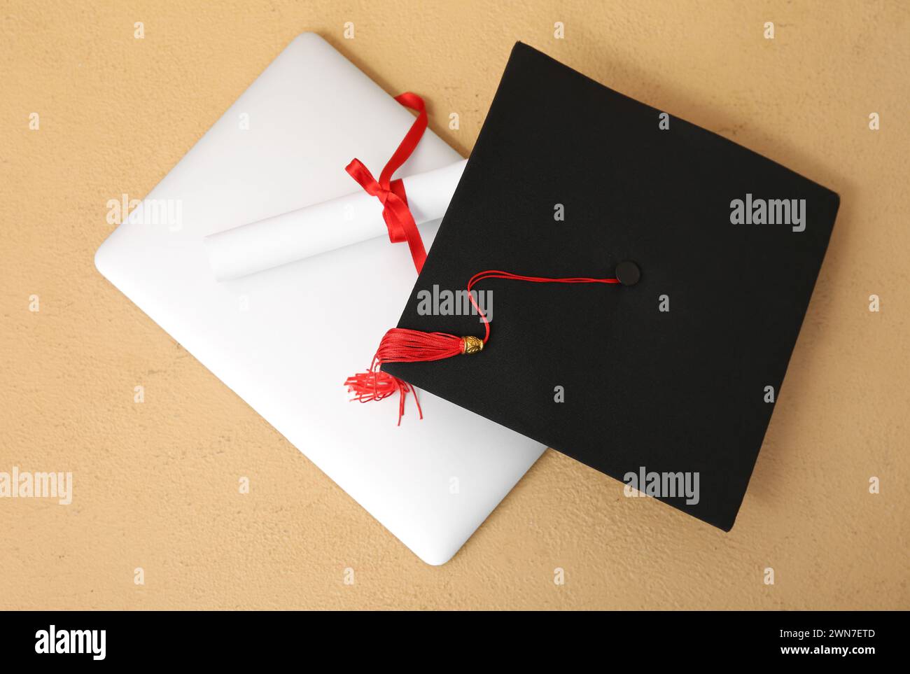 Mortar board with diploma and modern laptop on brown background Stock ...