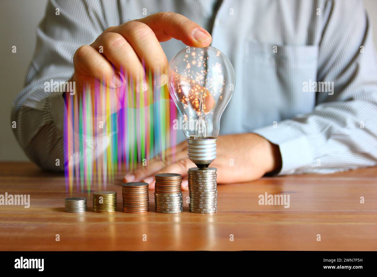 worker holding light bulb put on coin stacking with colorful , saving ...