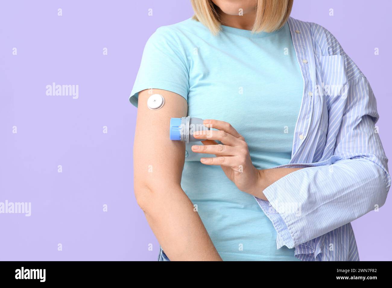 Woman with glucose sensor for measuring blood sugar level and ...