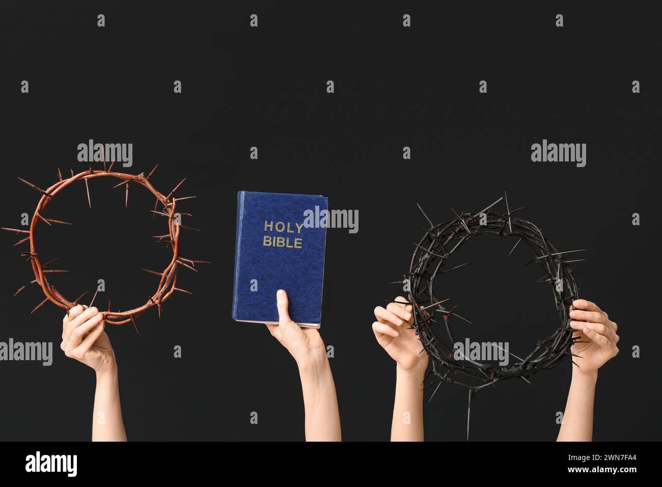 Female hands with Holy Bible and crowns of thorns on dark background ...