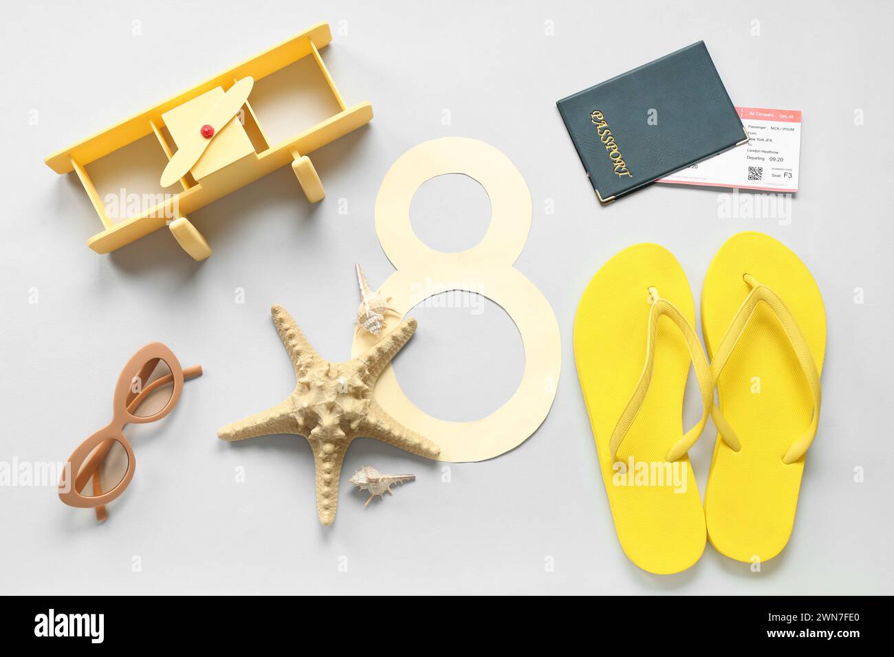 Composition with paper figure 8, beach accessories and toy plane on ...