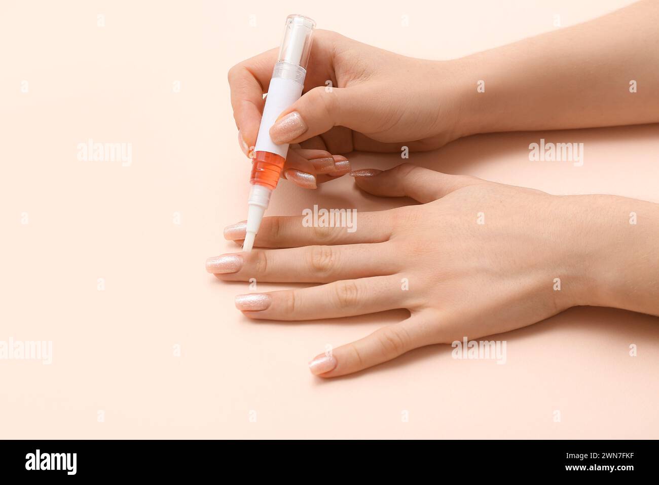 Female hands applying cuticle oil with pen on beige background Stock ...