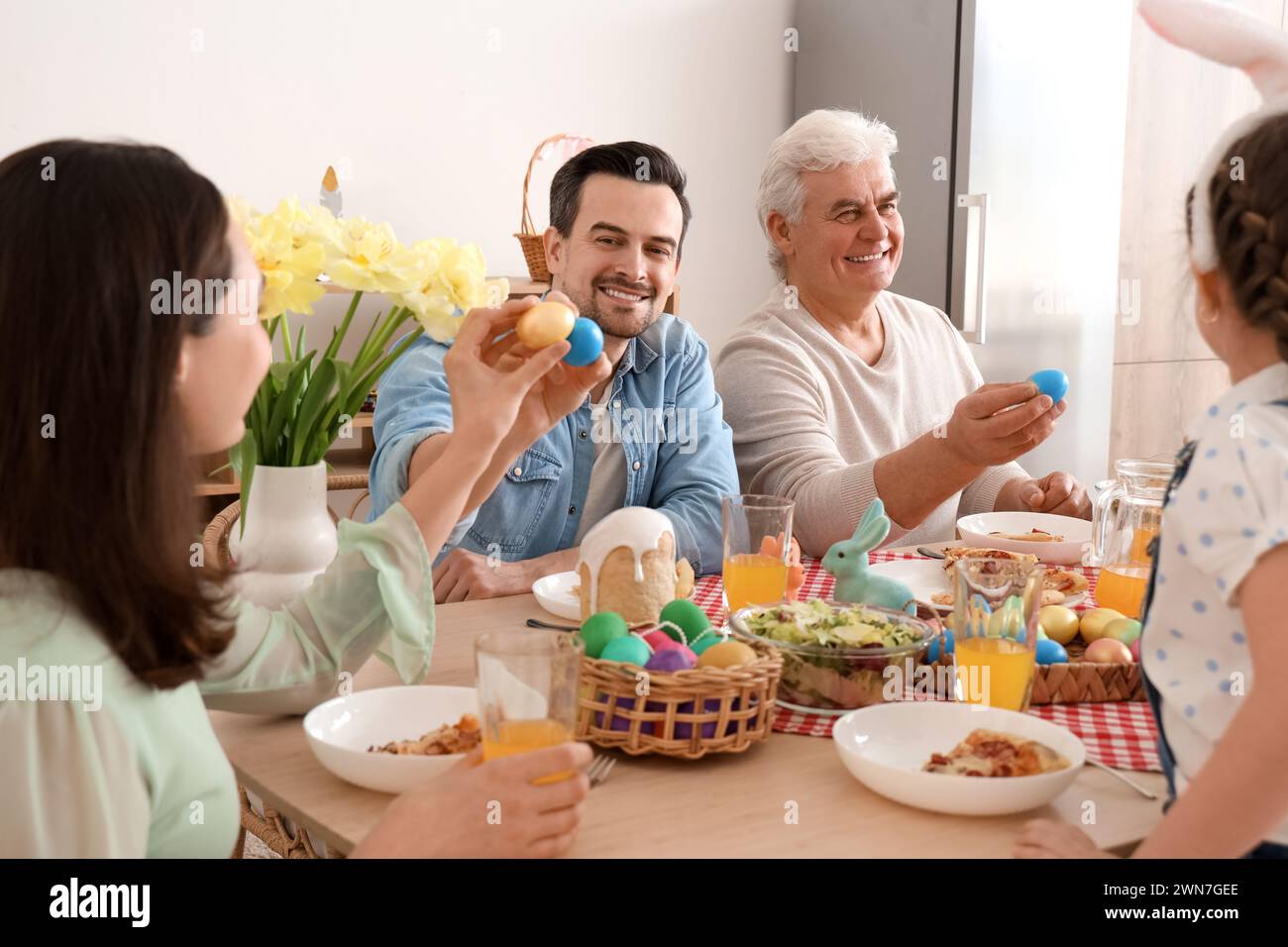 Happy family breaking Easter eggs at home Stock Photo - Alamy
