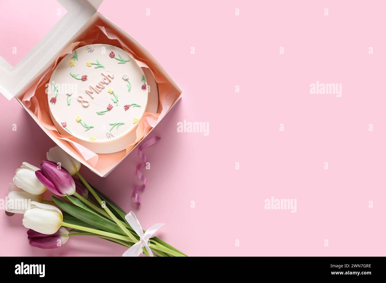 Box with sweet bento cake and bouquet of beautiful tulips on pink ...