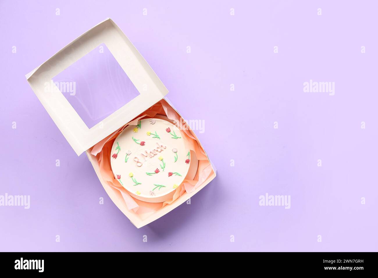Box with sweet bento cake on lilac background. International Women's ...