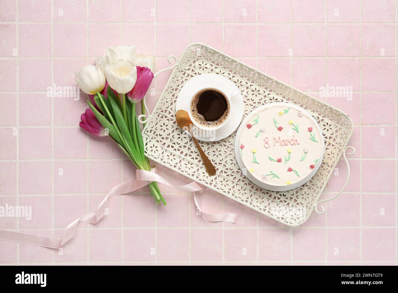 Sweet bento cake with cup of coffee and beautiful tulips on pink tile ...