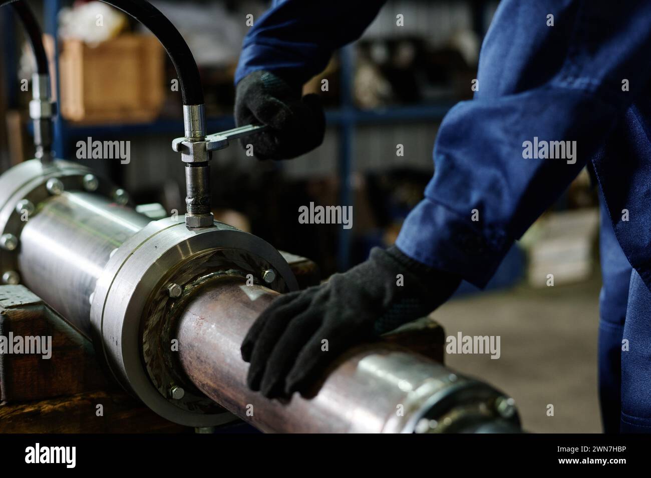 Unrecognizable man wearing uniform and gloves working in factory ...