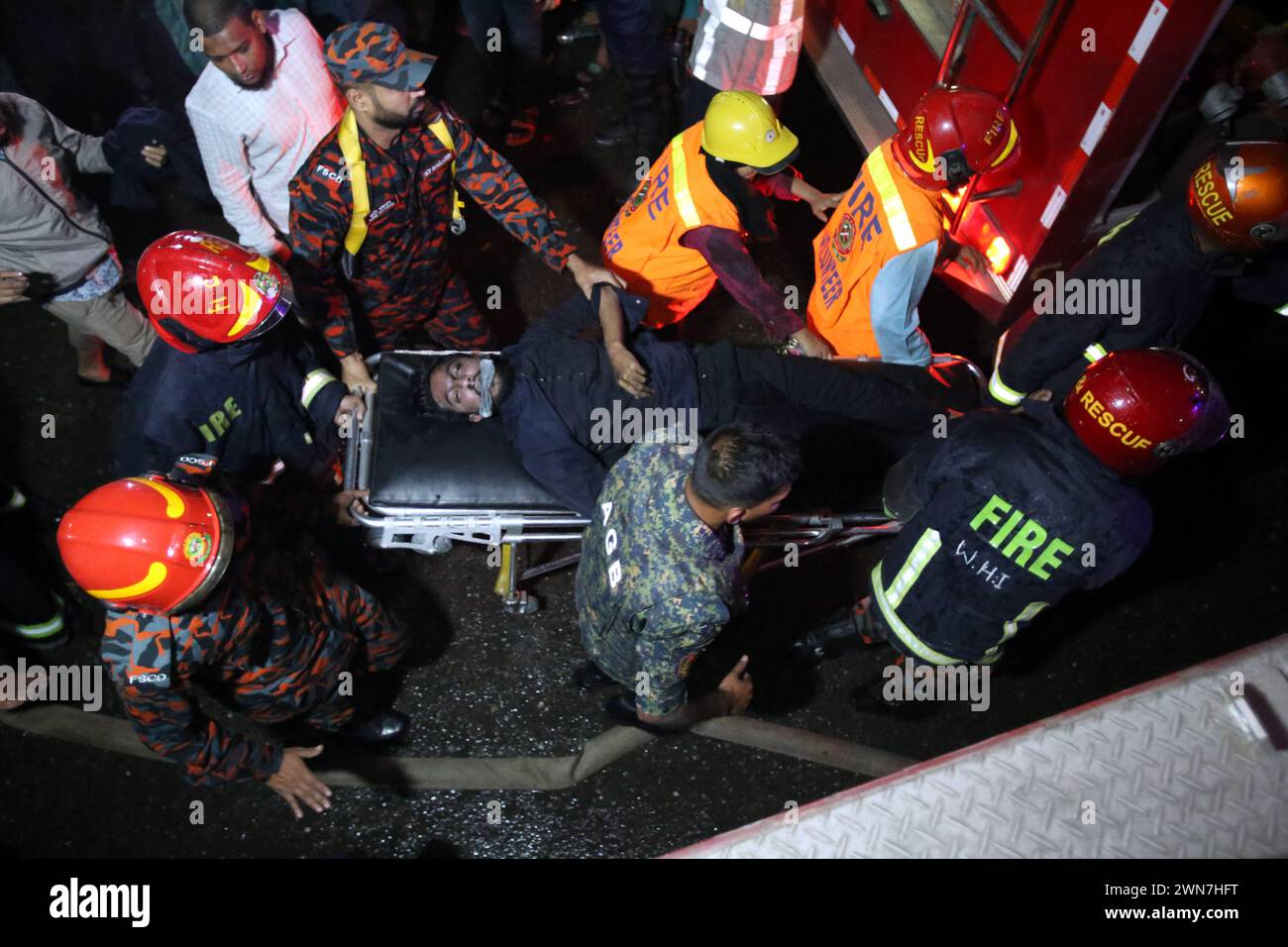 Dhaka, Bangladesh. 01st Mar, 2024. Graphic content/Firefighters carry an injured person during ...