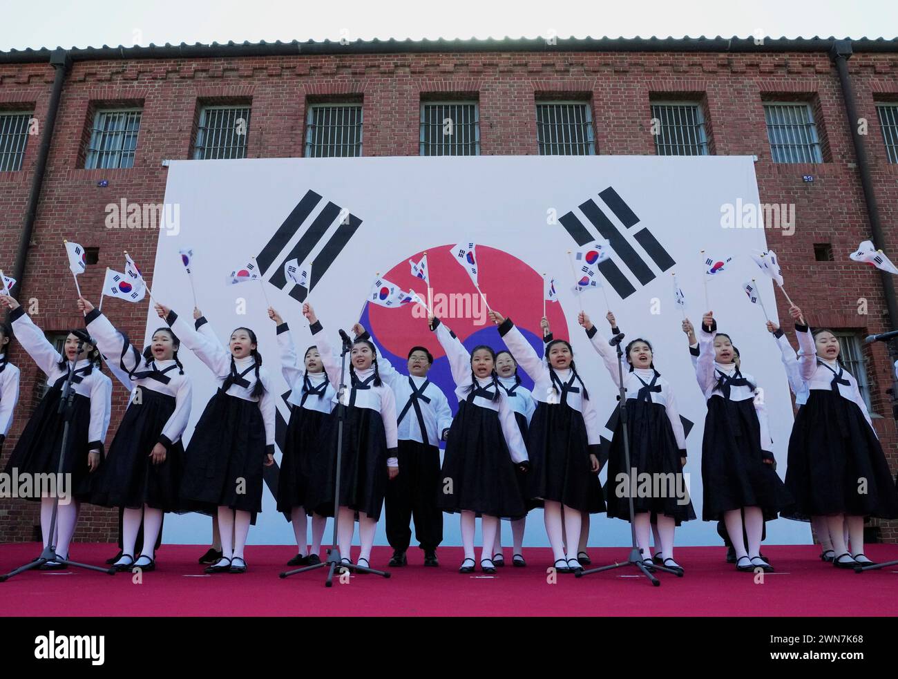 South Korean children wave national flags during a ceremony to ...