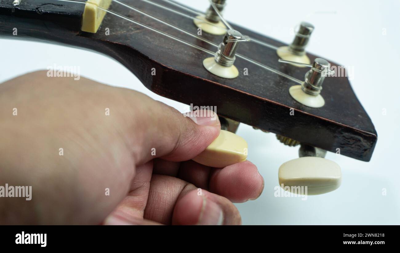 Ukulele with 4 strings being tuning on a white background Stock Photo ...