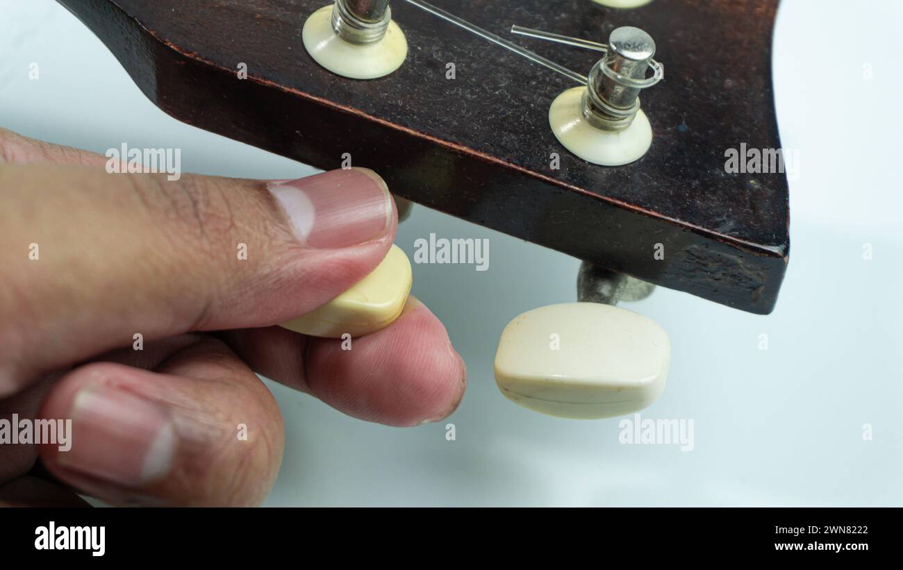 Ukulele with 4 strings being tuning on a white background Stock Photo ...