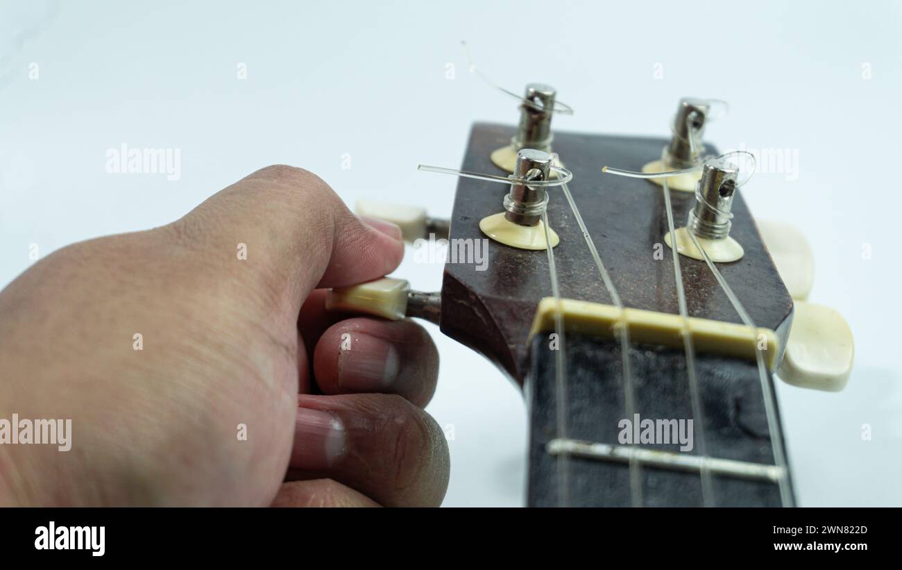 Ukulele with 4 strings being tuning on a white background Stock Photo ...