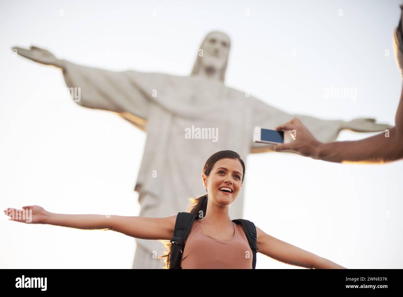 Woman, photo and jesus statue for travel, backpacking and happy on ...