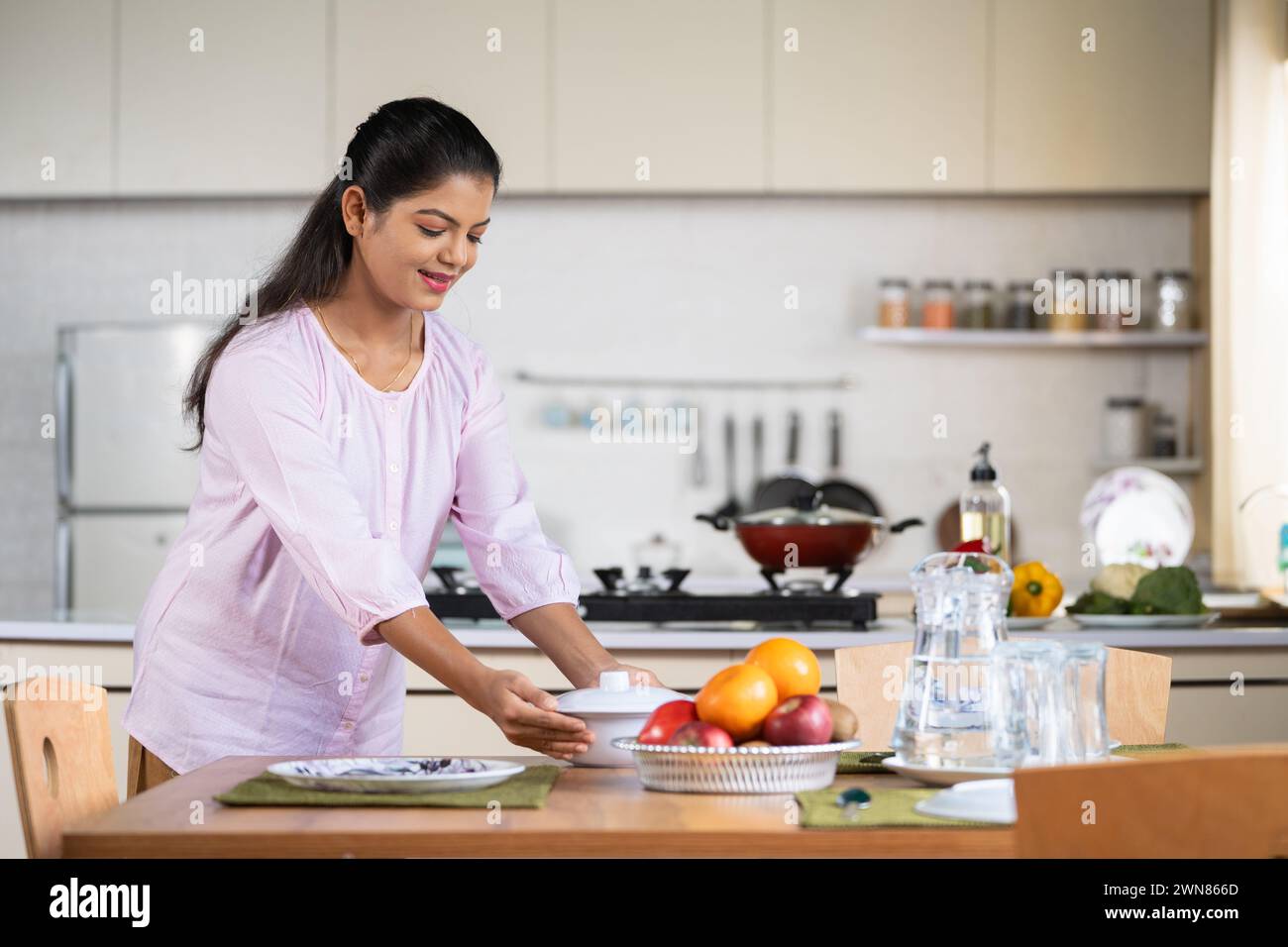 Happy Indian woman preparing dining table for breakfast at morning ...