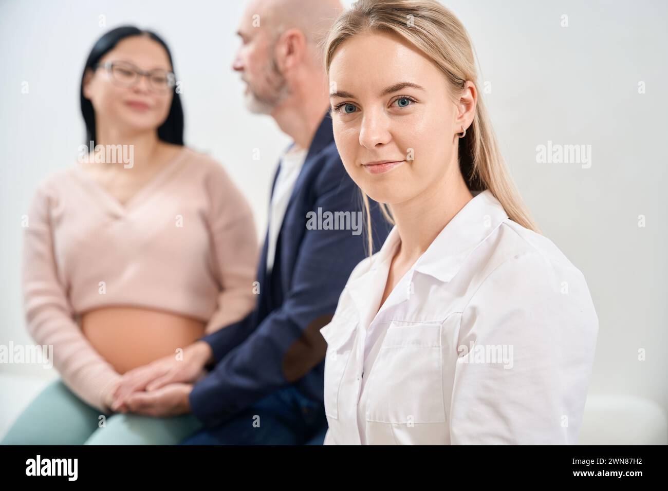 Smiling young woman doctor posing on camera in her office in private ...