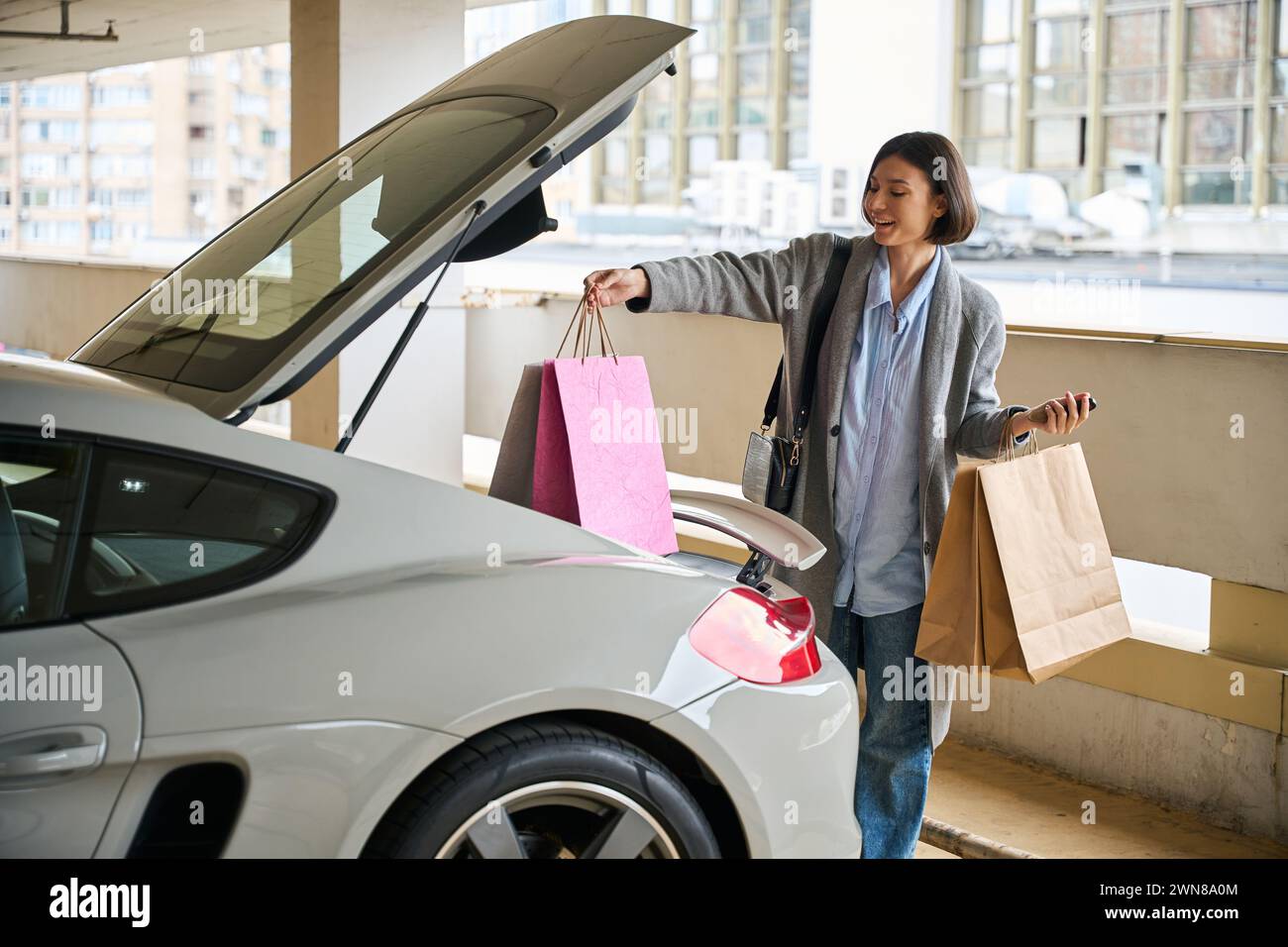 Cheerful female carrying, holding paper bags in hand Stock Photo - Alamy
