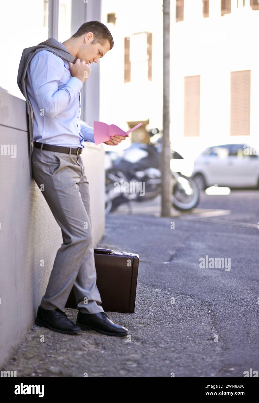 Business, job loss and man on street, fired and reading letter of ...
